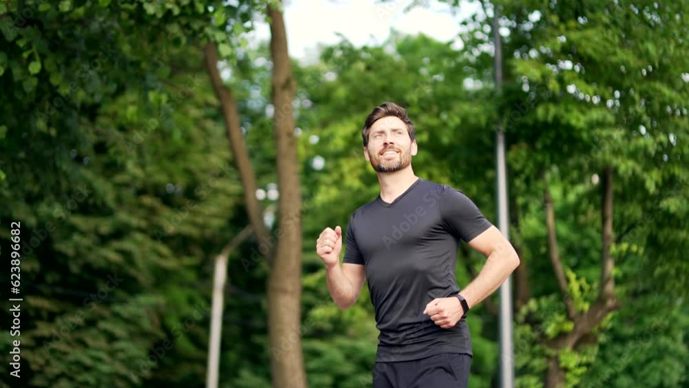 Handsome bearded male runner running on a urban park Sporty atlet man ...