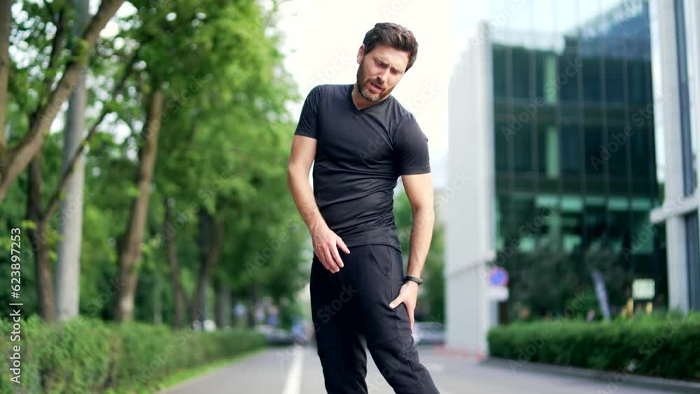 Athletic man massages a sprained leg injury during a workout run ...