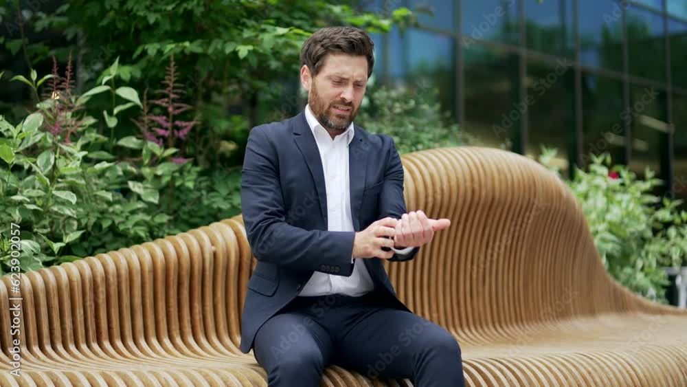 Sad man sitting on bench scratching body has dry skin problems ...