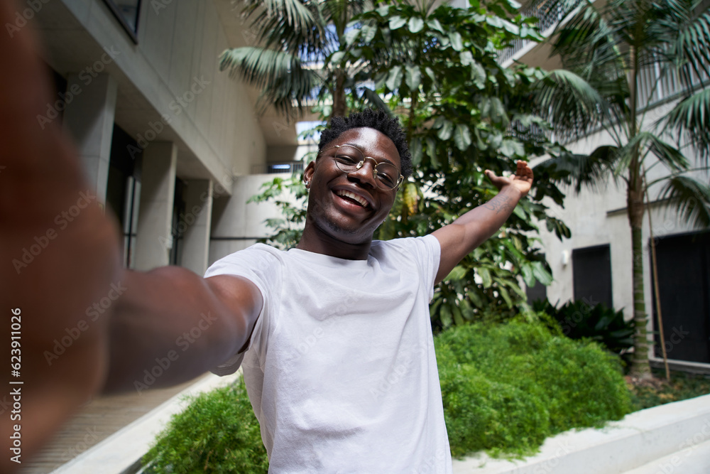 Selfie of a young black man standing outside and laughing with a hand ...