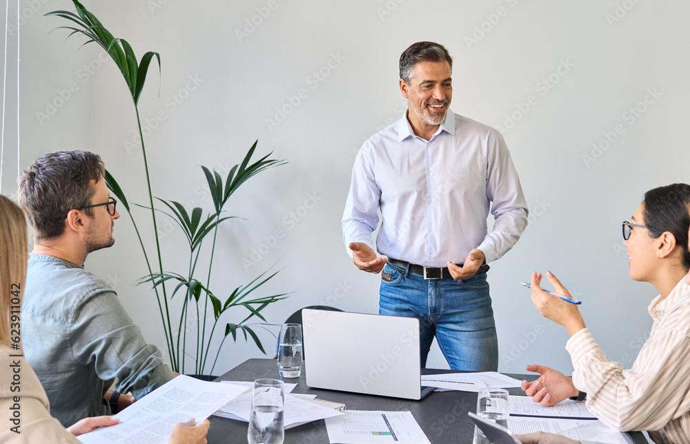 Older Latin company manager leading team meeting in office. Happy ...