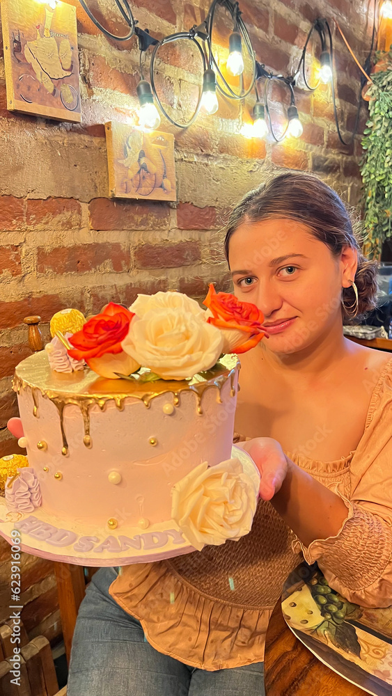 Beautiful young woman with a cake in her hands. A girl with a cake in ...