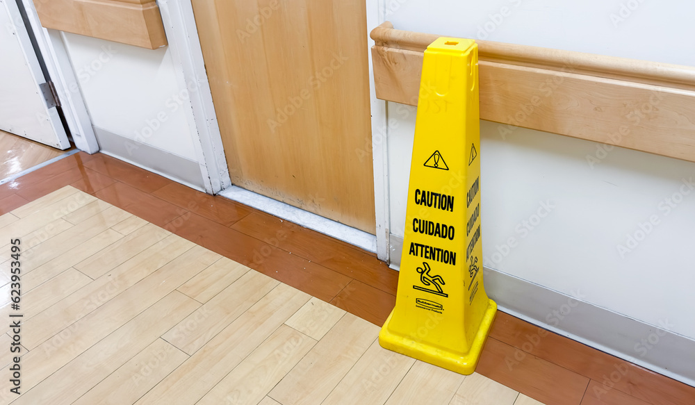 Bright yellow caution sign with 'wet floor' text symbolizes potential ...