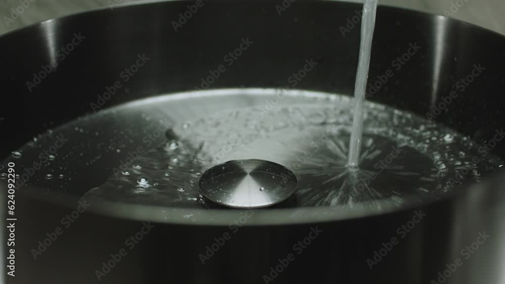 Pouring splashing of washing water in sink . Water pours from tap ...