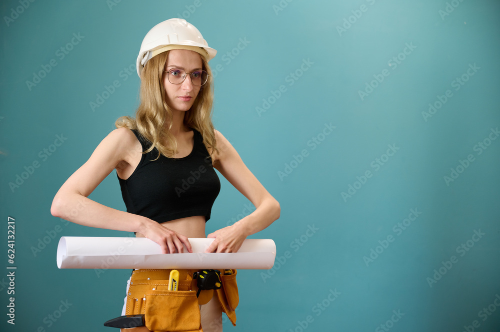 Young architect girl with protective helmet holding a house plan in ...