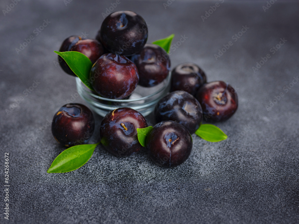 Sweet plums on dark background. Fresh blue plums with leaves. Food ...