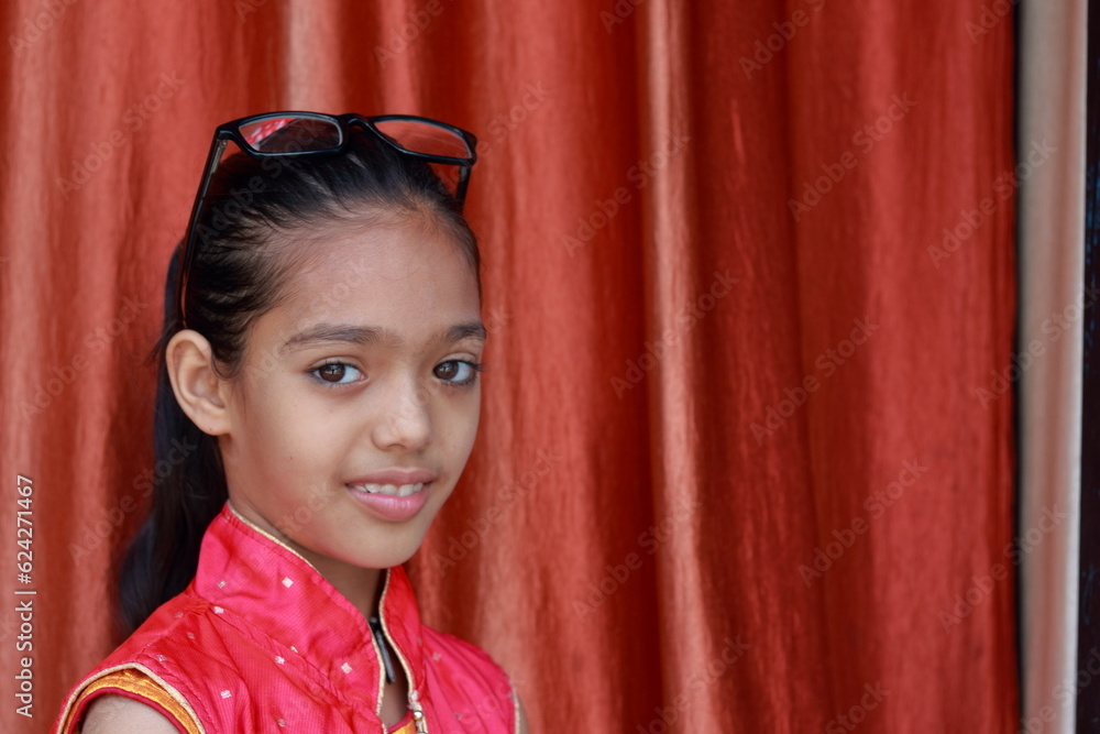 An Indian little pretty girl fiddling with her eye glasses in various ...