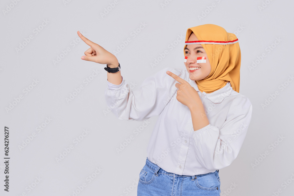 Portrait of smiling young Asian Muslim woman wearing a hijab showing ...