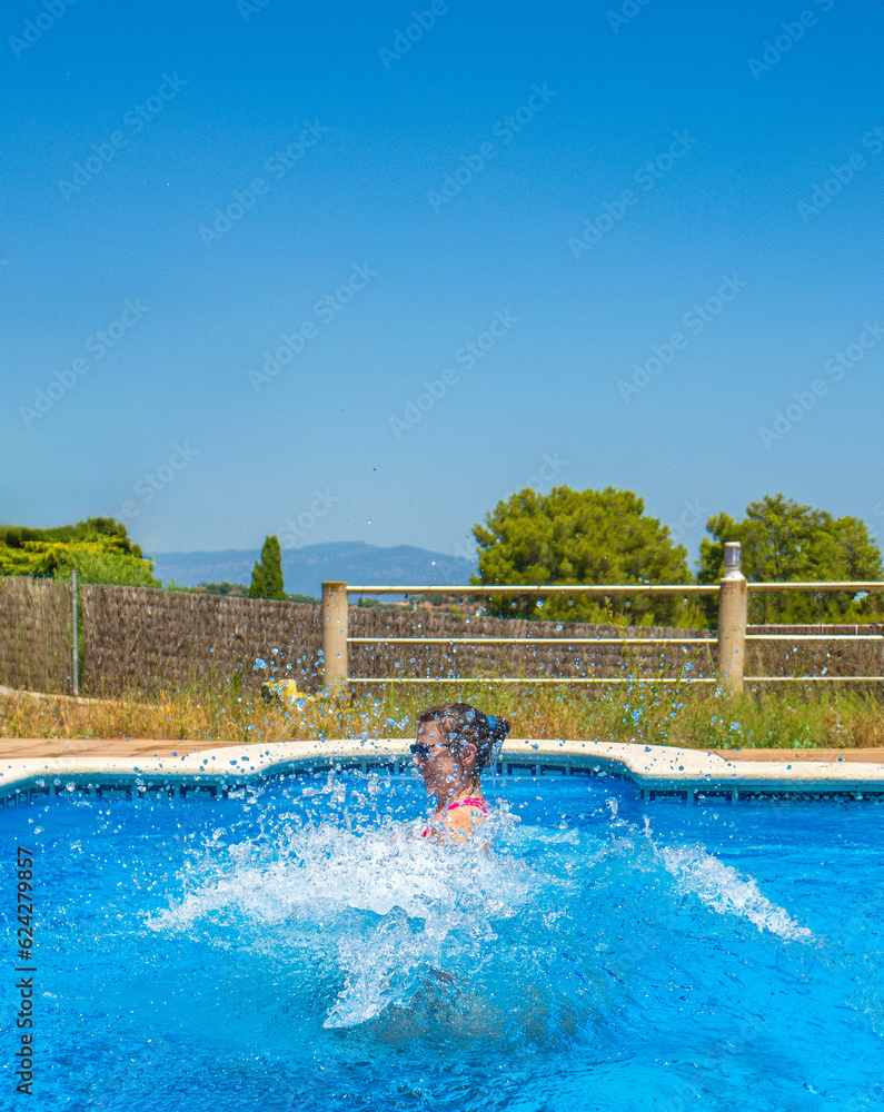 Head of a laughing young woman wearing sunglasses out of the water ...