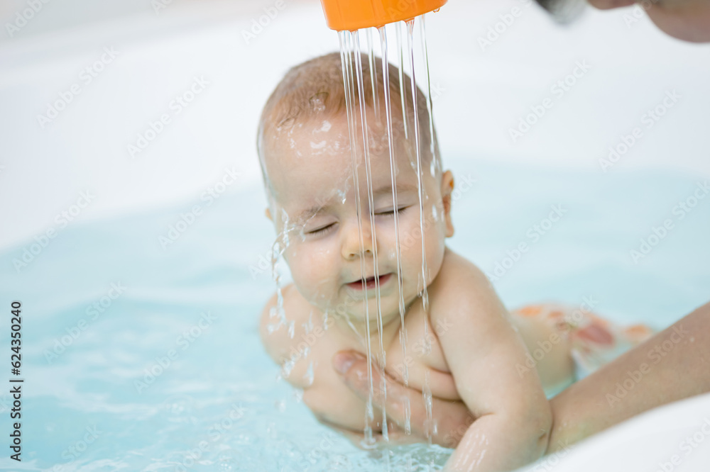 Baby girl splashes hands and kicks legs trying to swim forward in ...