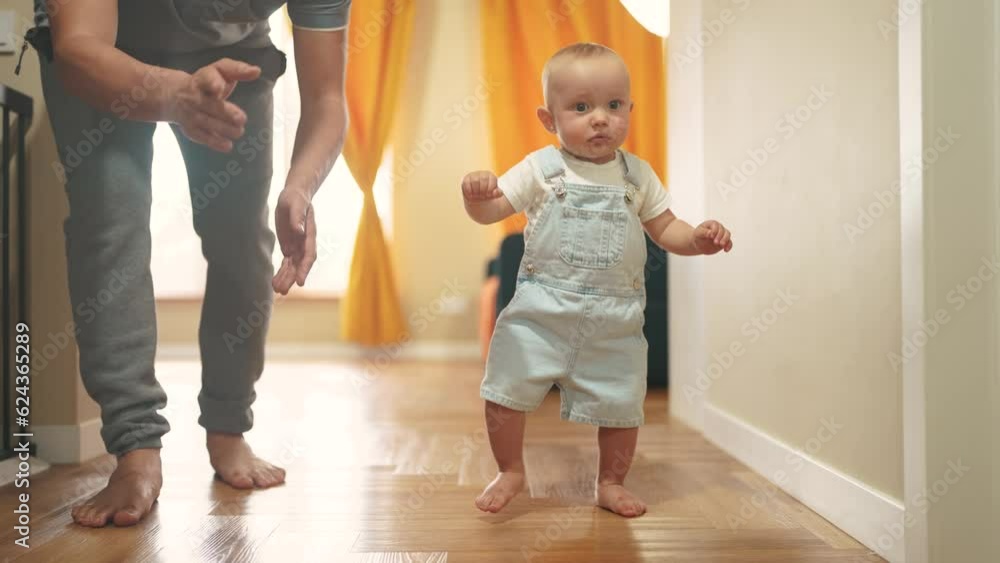 baby first steps. baby goes to her father at window learns to walk to ...