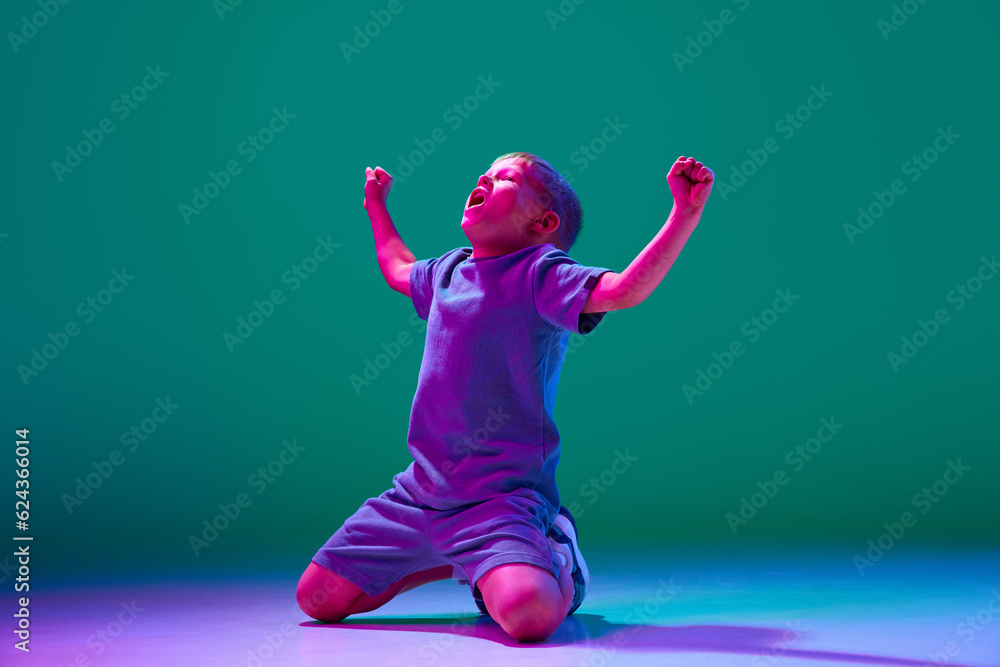Emotional child, little boy sitting on knees with raise hands, showing ...