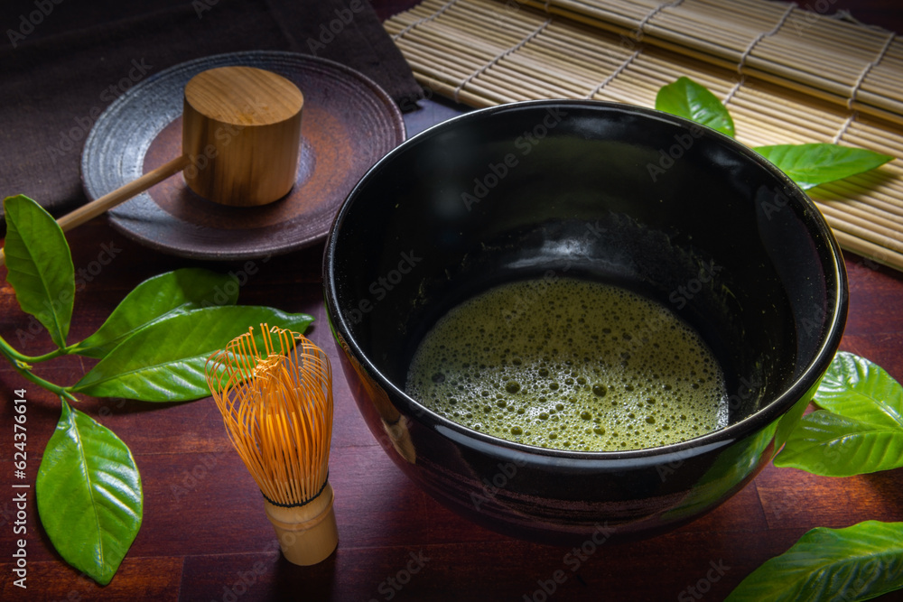 matcha green tea and leaf in black bowl chawan decorated Chasen, a ...