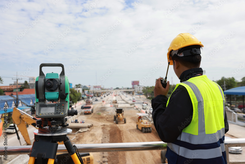 Civil or survey technician working at new road construction site with ...