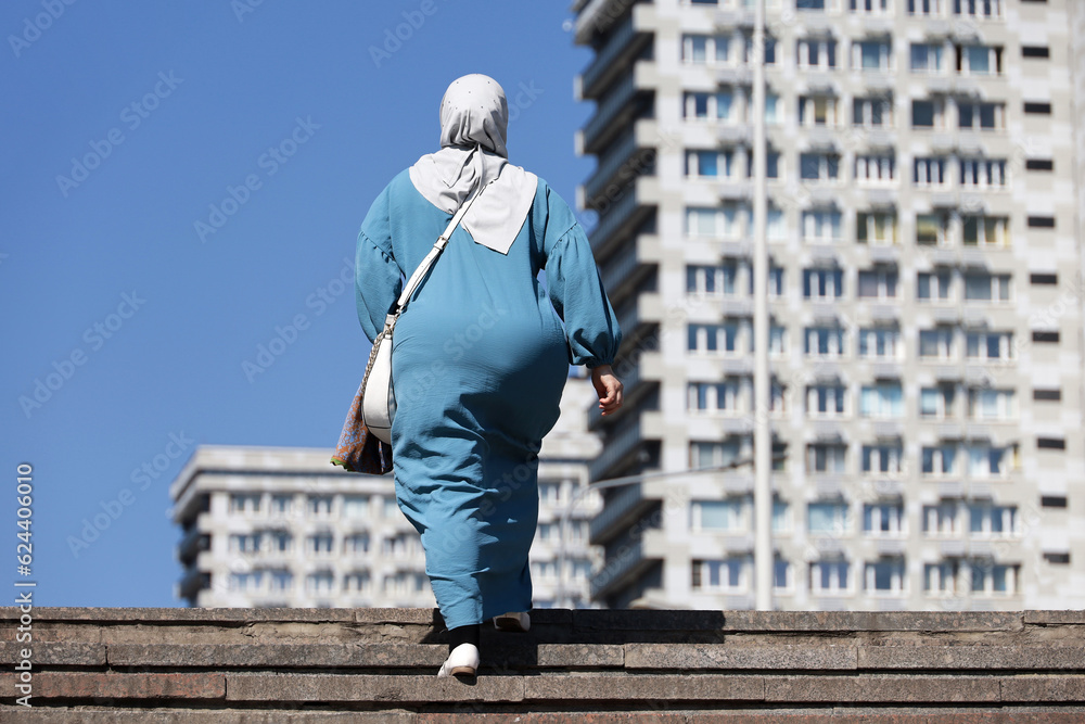 Muslim woman in hijab walking on a city street in summer Stock Photo ...