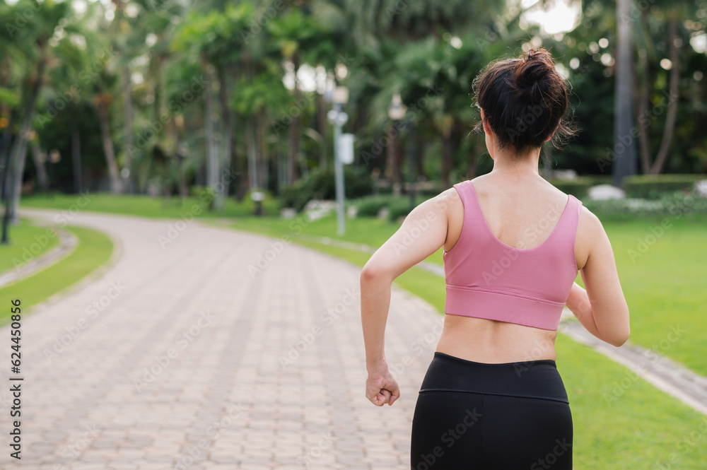 Woman jogger. back perspective portrait of young asian female wearing ...