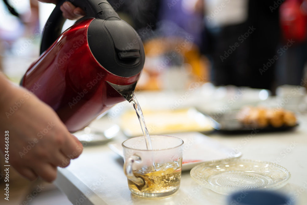 pouring boiling water from an electric kettle into a mug Stock Photo ...