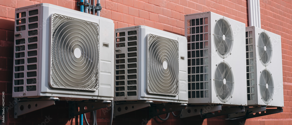Air conditioner compressor installed on the wall of a building, along ...