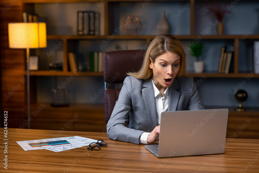 Shocked young business woman using laptop looking at computer screen ...