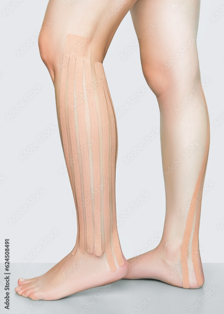 female legs with beige kinesio tapes. lymphatic drainage foot taping ...