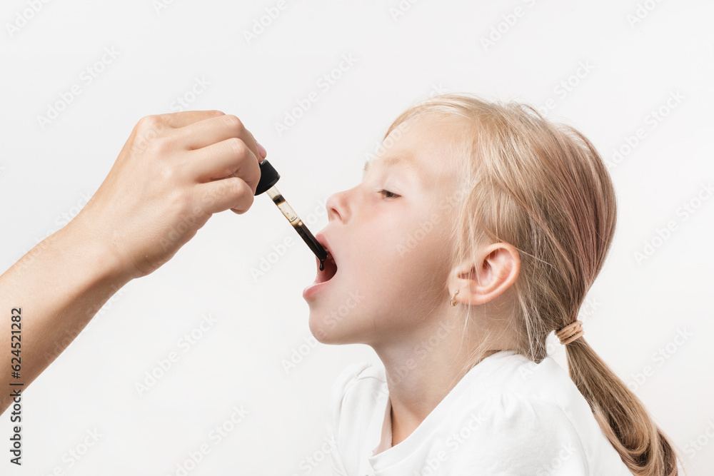 Portrait of happy cute caucasian girl taking supplement or medicine ...