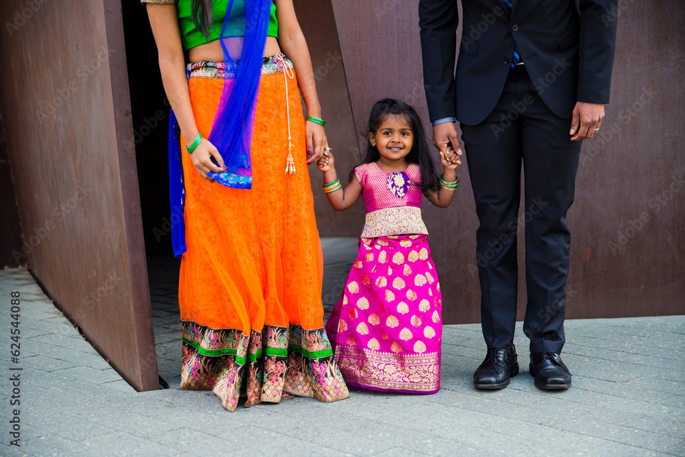 close up of little indian girl wearing a sari and bindi holding hands ...
