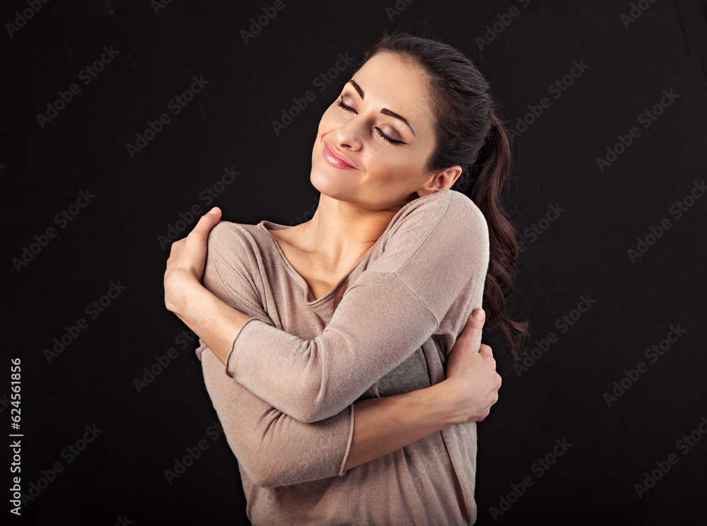 Beautiful happy calm smiling woman hugging herself with love on studio ...