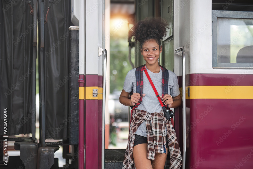 Traveler african asian american woman getting in a train to hop on ...