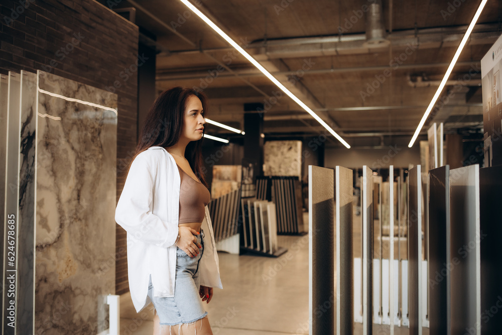 Happy brunette female interior designer choosing flooring tile color ...