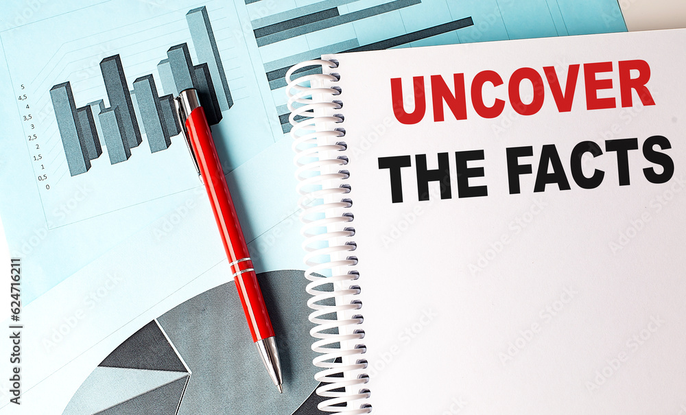 UNCOVER THE FACTS text on a notebook with pen on a chart background ...