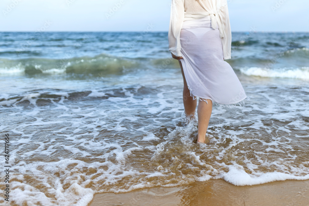 Beautiful girl in the sea. The woman enters the sea. Blue ocean. Girl ...