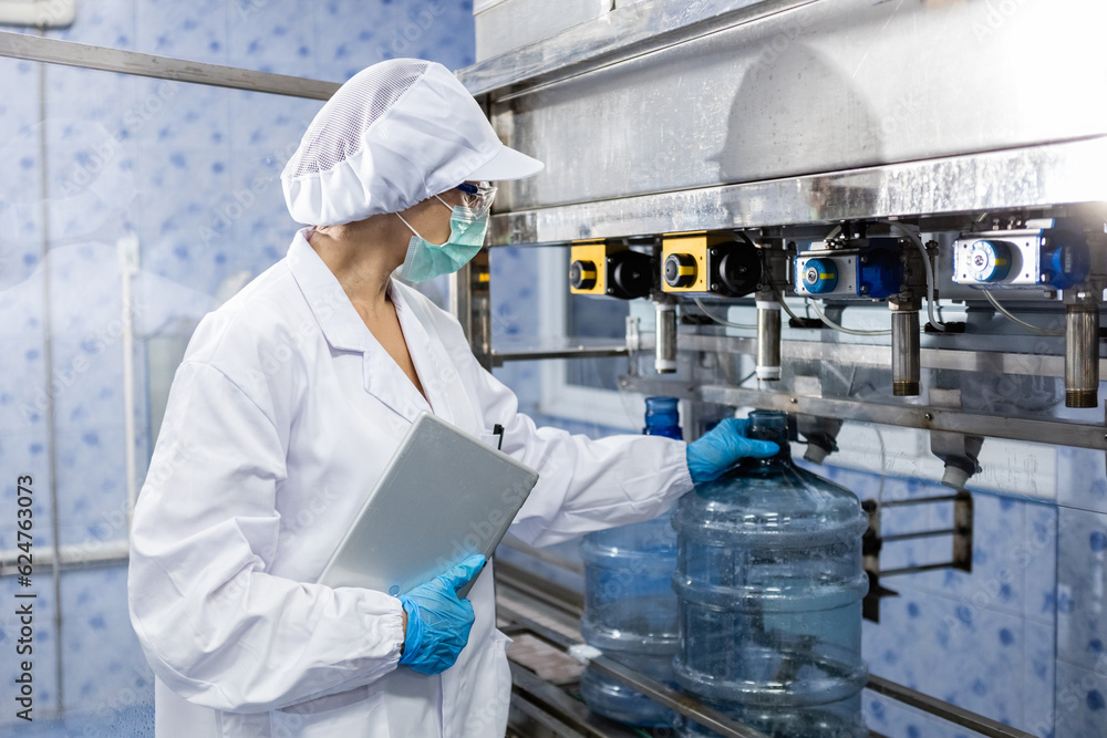 Female worker checking quality drinking water management system before ...