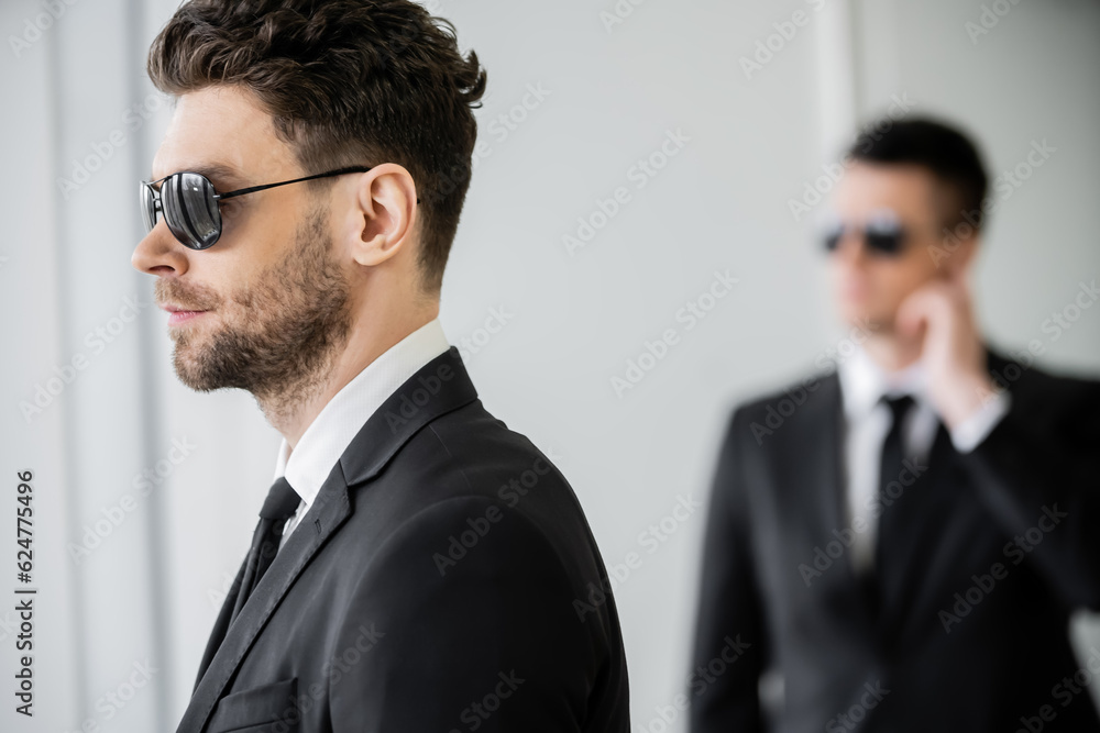 surveillance, bodyguard in sunglasses and black suit with tie, hotel ...