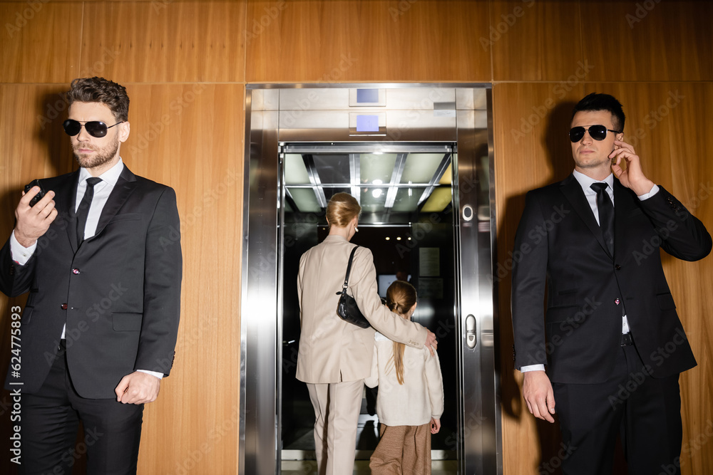 private safety, mother and daughter entering elevator of luxurious ...