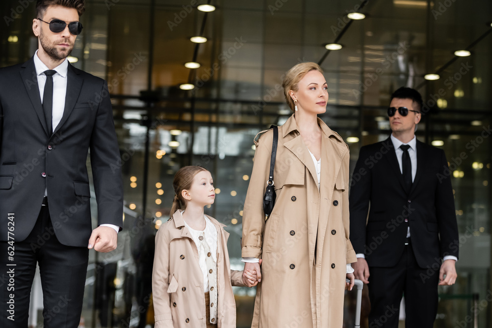 Foto de bodyguards walking next to blonde successful woman and preteen ...