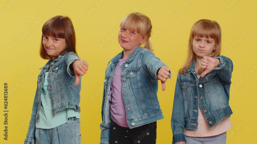 Upset teenage girls showing thumbs down sign gesture, expressing ...