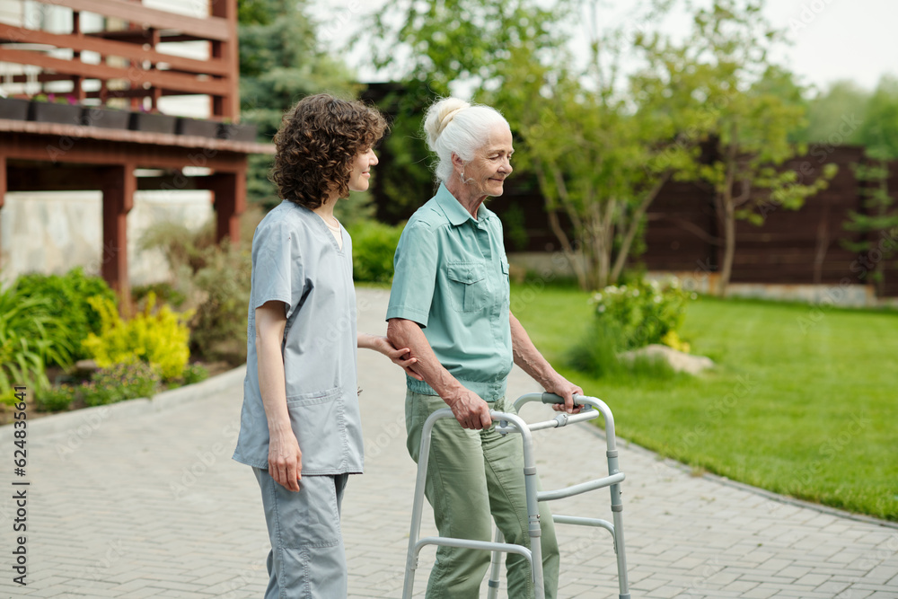 Foto de Young caregiver supporting hand of senior patient of retirement ...