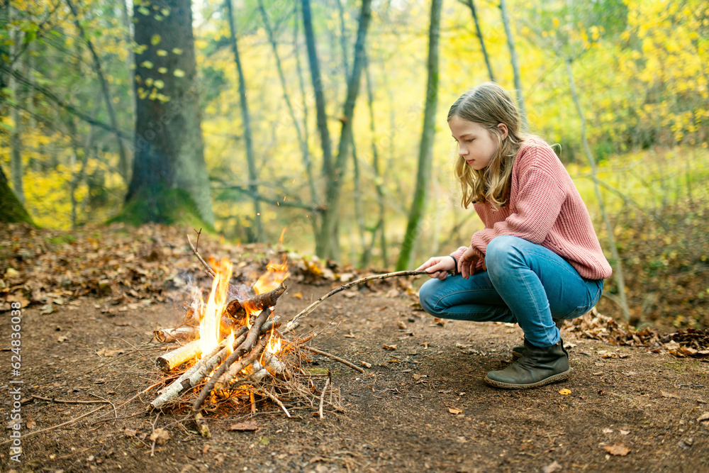 Cute preteen girl roasting marshmallows on stick at bonfire. Child ...