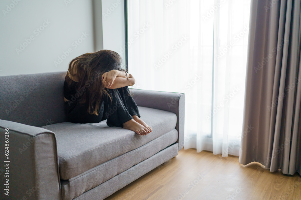 Sad woman thinking about problems sitting on a sofa upset girl feeling ...