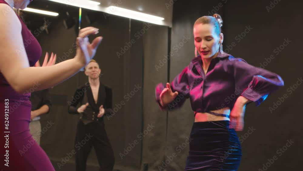 Medium slowmo of two young Caucasian dressed up women making sensual ...