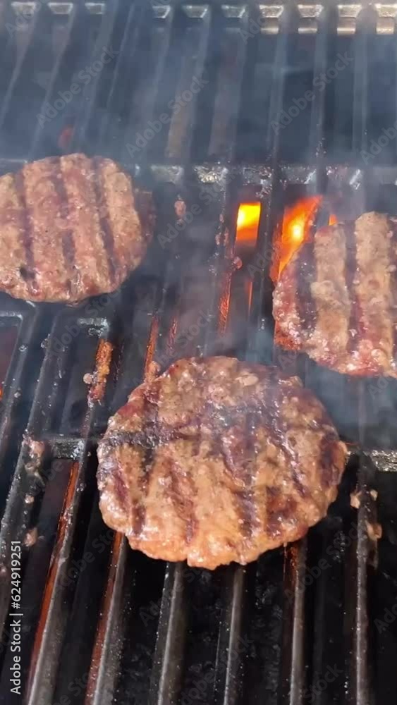 steak bbq burger patties fry over an open fire on the grate flip flame ...