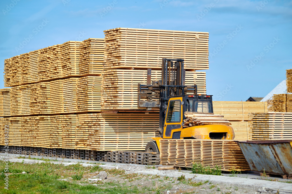 Forklift loading lumber wood boards in stack, finished product ...