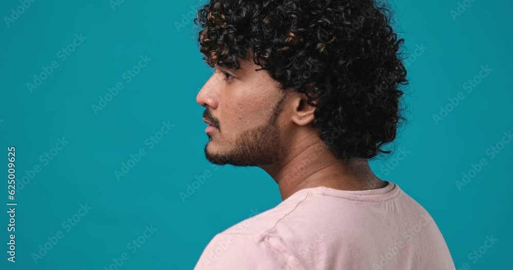 Young serious calm indian man standing with his back to the camera ...
