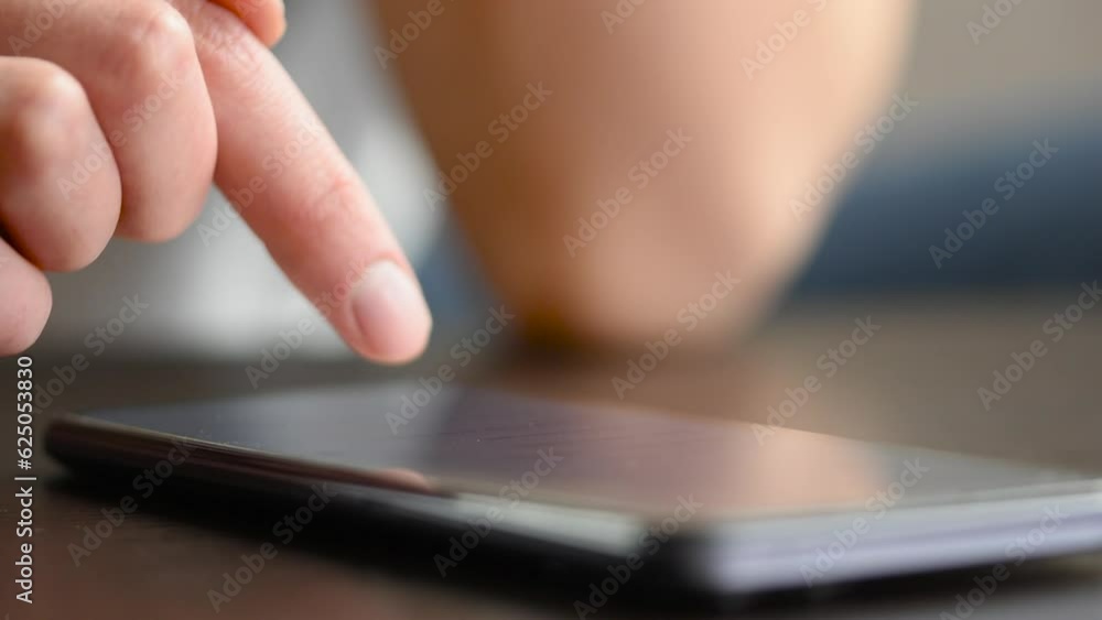 a woman's hand presses and flips through the screen of a smartphone ...