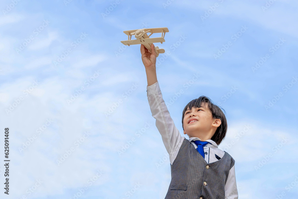 Cute Asian young boy playing wooden aviator toy air plane imagination ...
