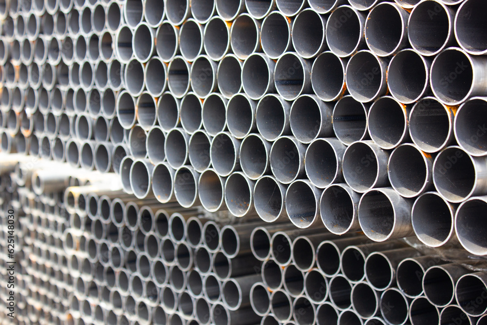 Metal pipes stack, industrial warehouse, production of metal pipes ...