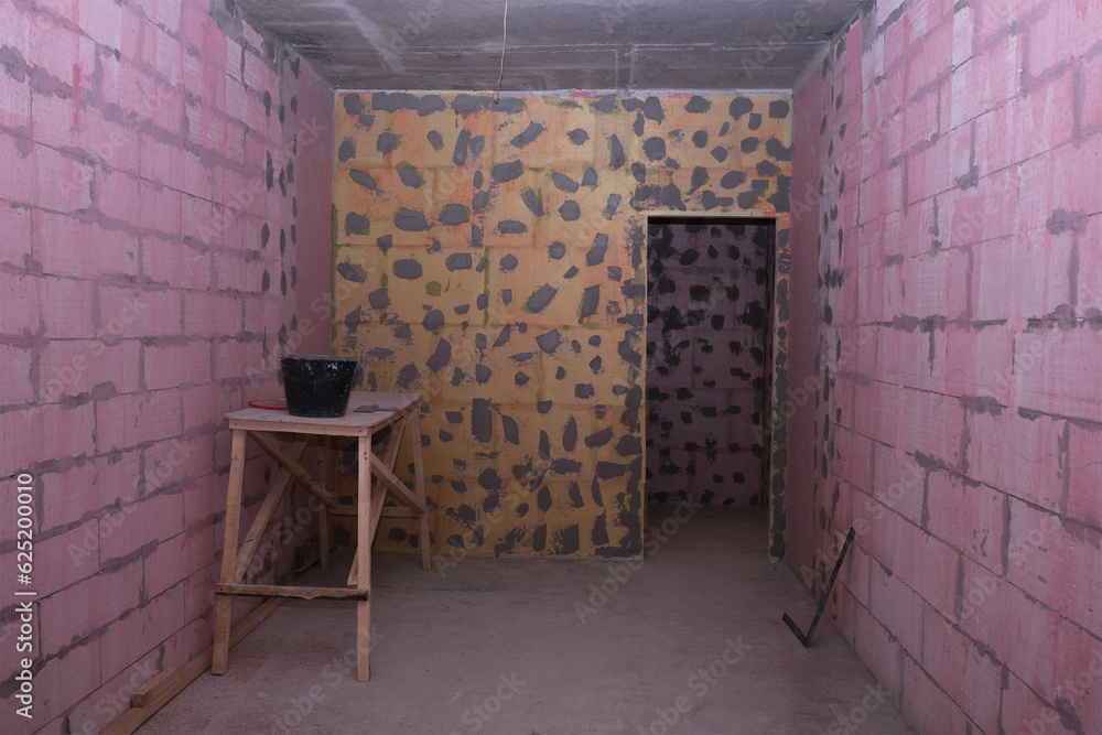 Construction. Walls in the room with pink and yellow primer ...