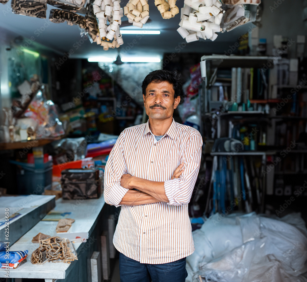 Indian hardware shop owner, salesman, vendor or seller showing products ...
