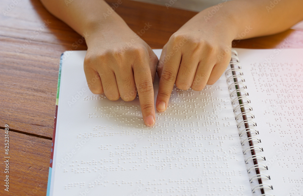 Visually impaired person reads with his fingers a book written in ...