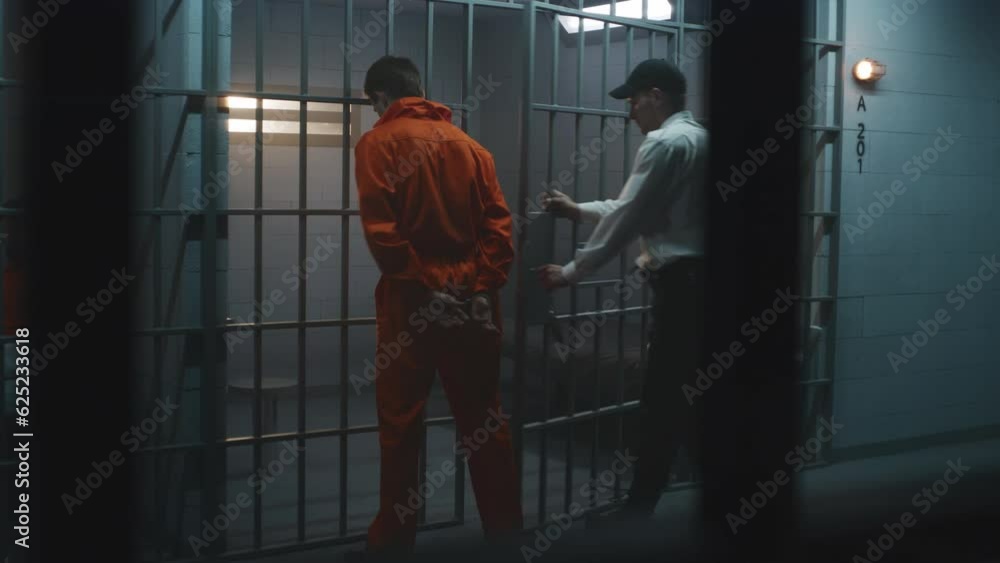Prison officer opens prison cell. Male prisoner in orange uniform ...